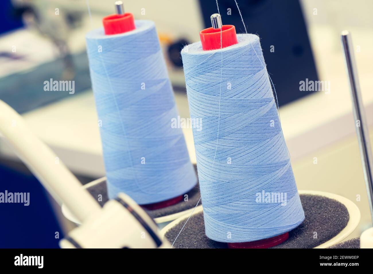 Reels of textile yarn blue thread at industrial weaving manufacturing ...