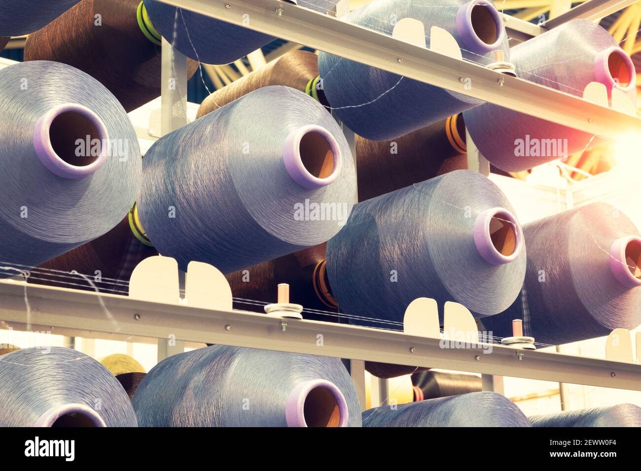 Reels of textile yarn blue thread at industrial weaving manufacturing ...