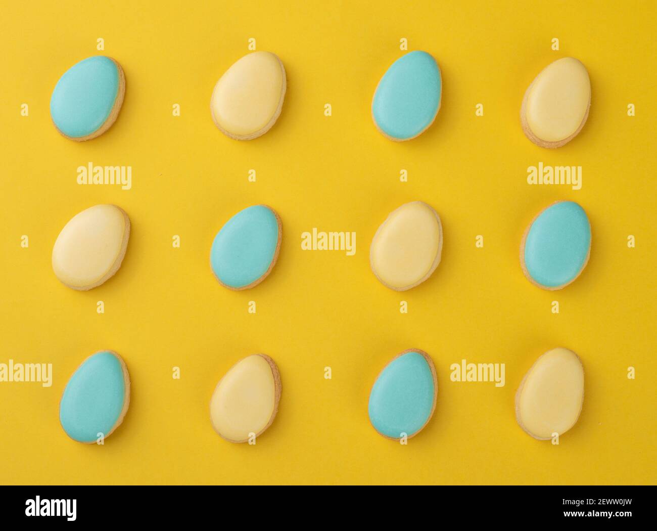 Blue and yellow easter egg cookies over yellow background Stock Photo ...