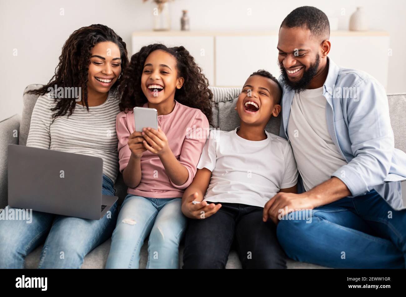 Happy african american family holding and using gadgets Stock Photo - Alamy