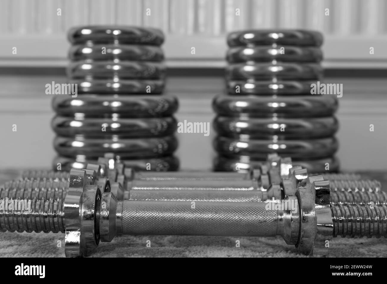 Black and white photo of weight lifting equipment on the floor at home ...