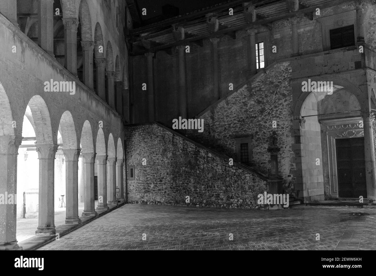 A greyscale photo of the inside of an ancient building with arcs and ...