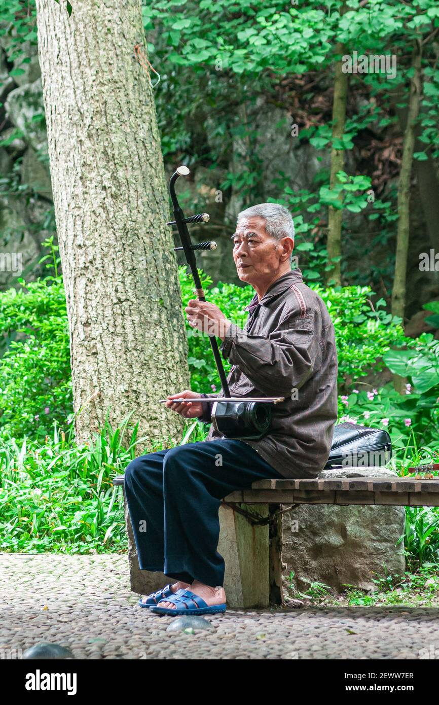 Guilin, China - May 11, 2010: Seven Star Park. Man sitting on bench ...