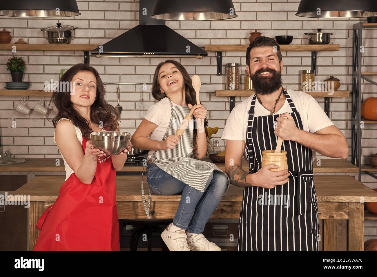 Family time. small girl with mom and dad in kitchen. do everything ...