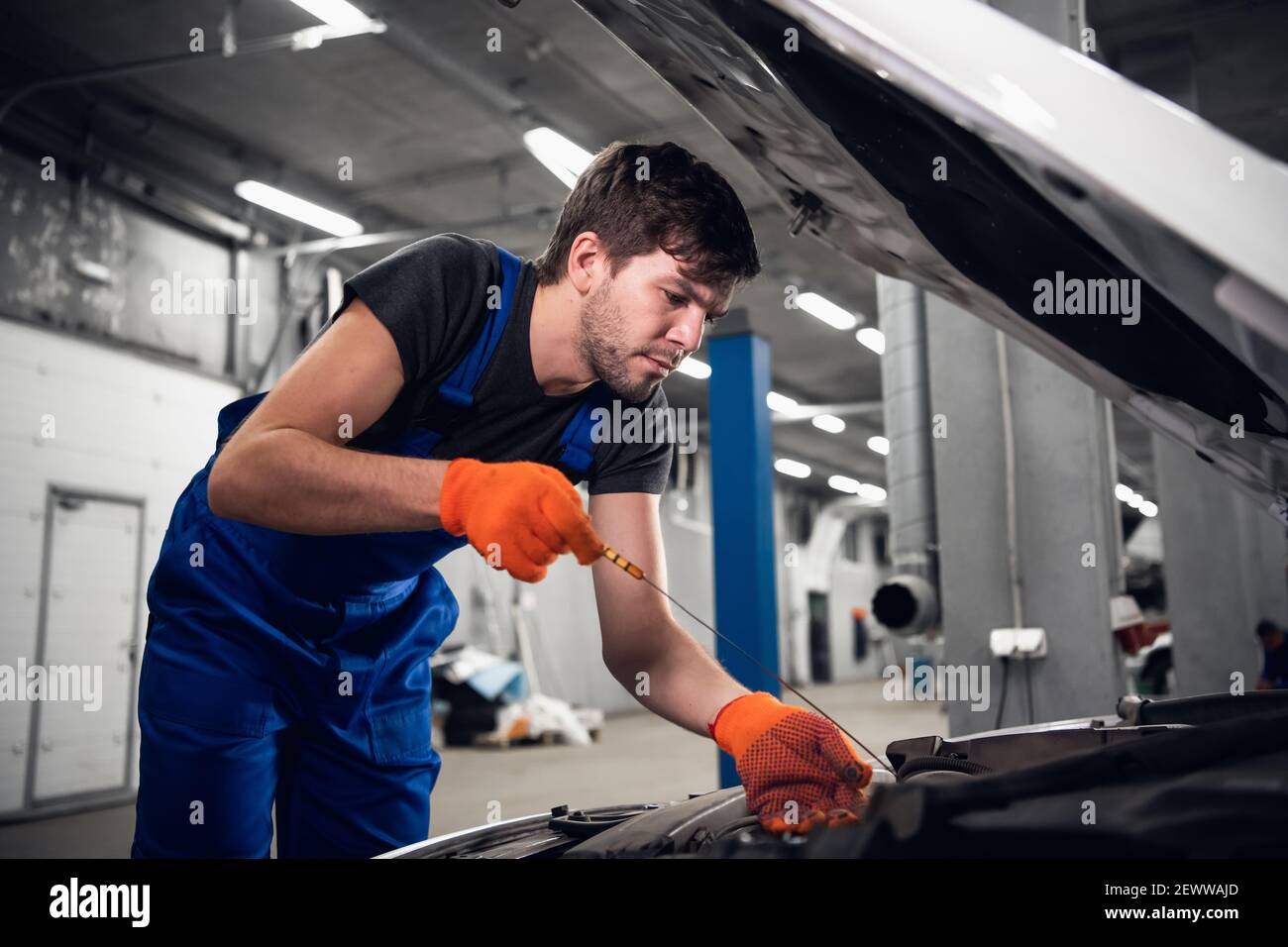 A worker uses tools to fix a car engine Stock Photo - Alamy
