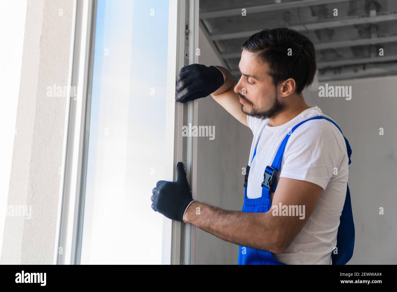 The craftsman installs a window frame in the room Stock Photo - Alamy