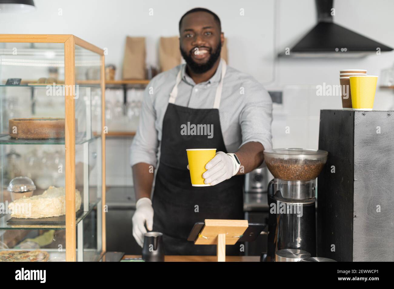 Glad African-American waiter, bakery owner, manager giving cup of ...