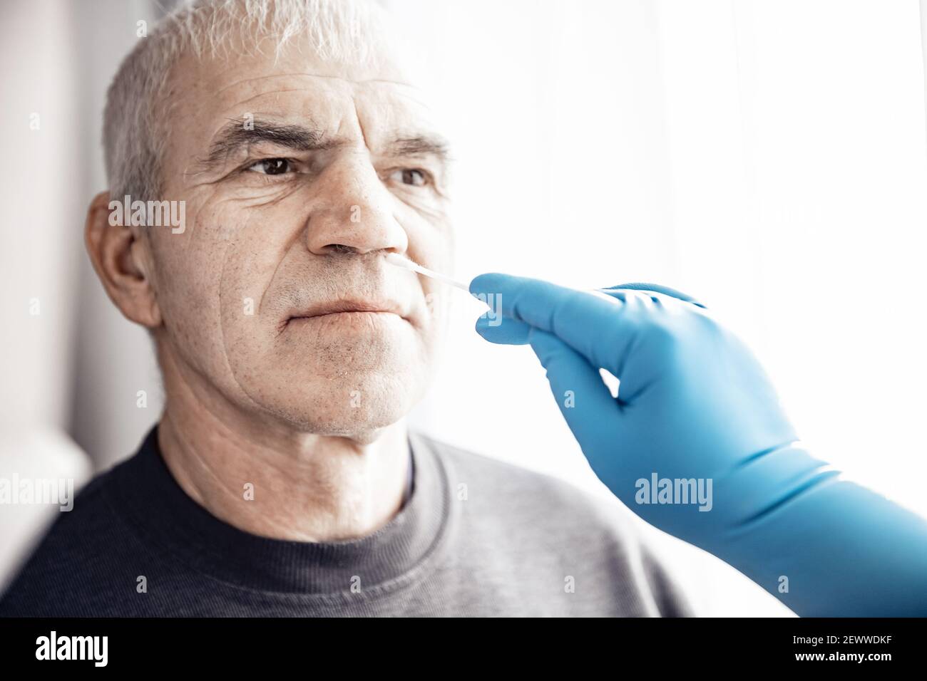Medical worker wearing protective equipment testing senior old man for ...