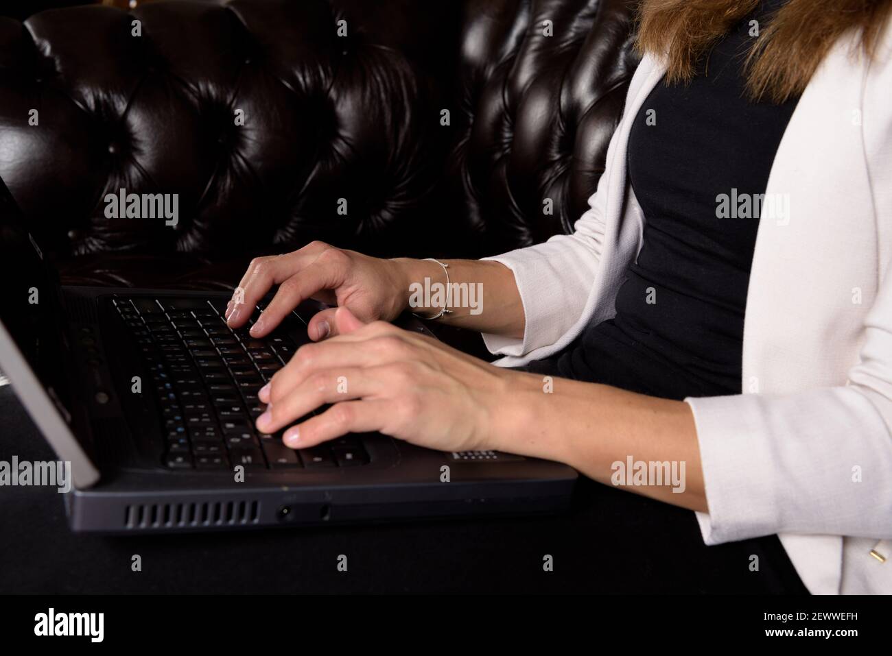 Hands of business woman sitting on sofa typing on keyboard Stock Photo ...