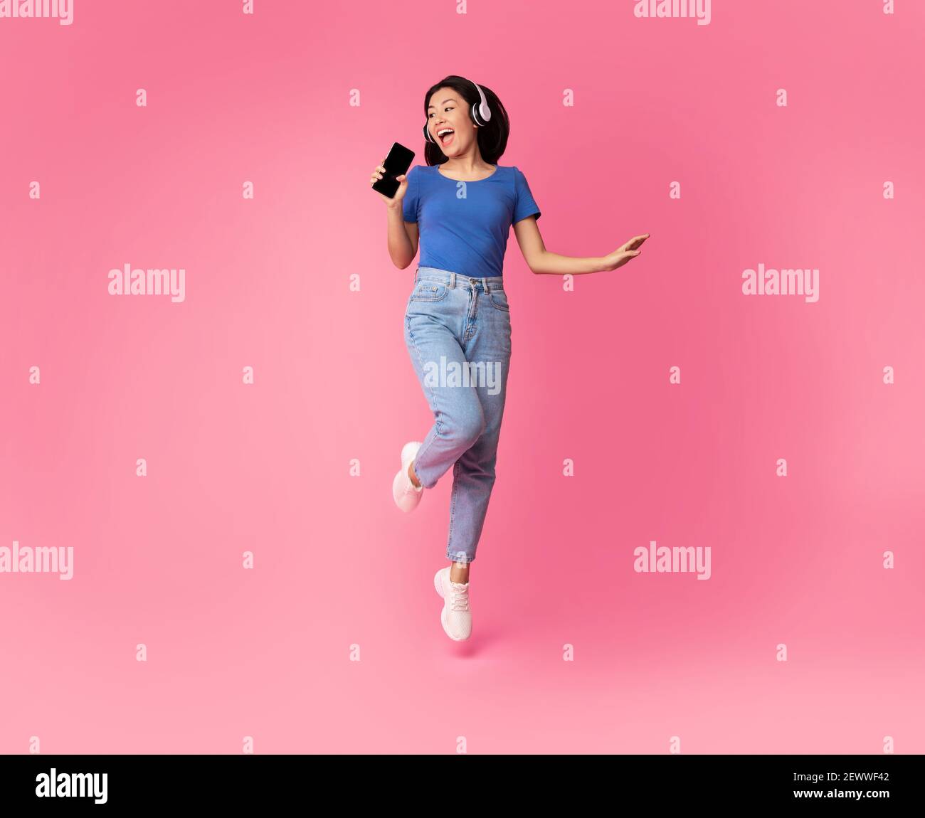 Happy asian woman singing using smartphone as mic Stock Photo - Alamy