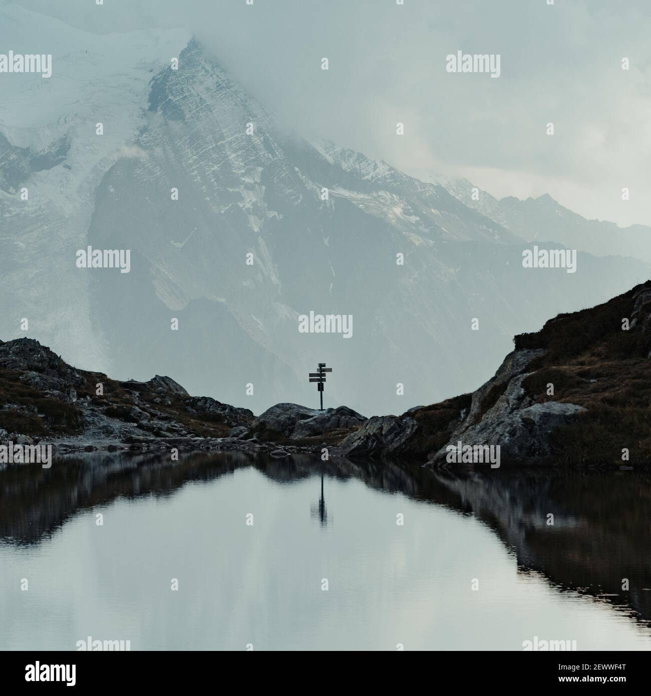 A vertical shot of signs and a lake at the scenic snowy French Alps ...