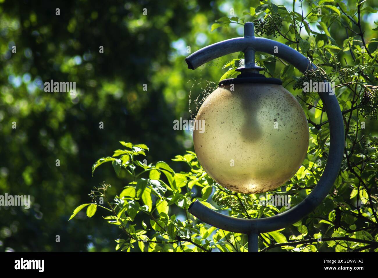 An old ball-shaped street lamp. In the background, the perfectly blue ...