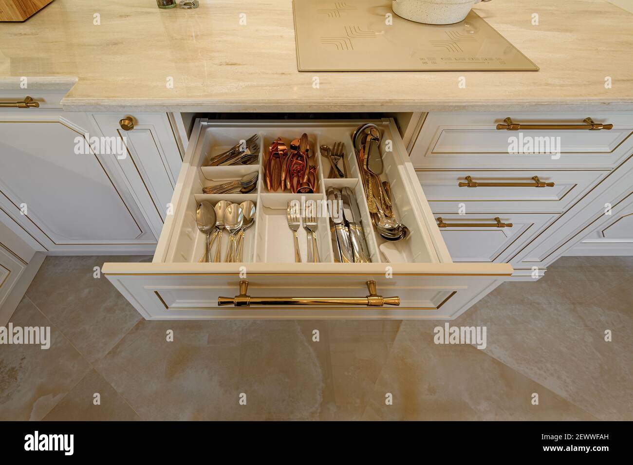 Drawer pulled out in cabinet at luxury beige and gold classic kitchen ...