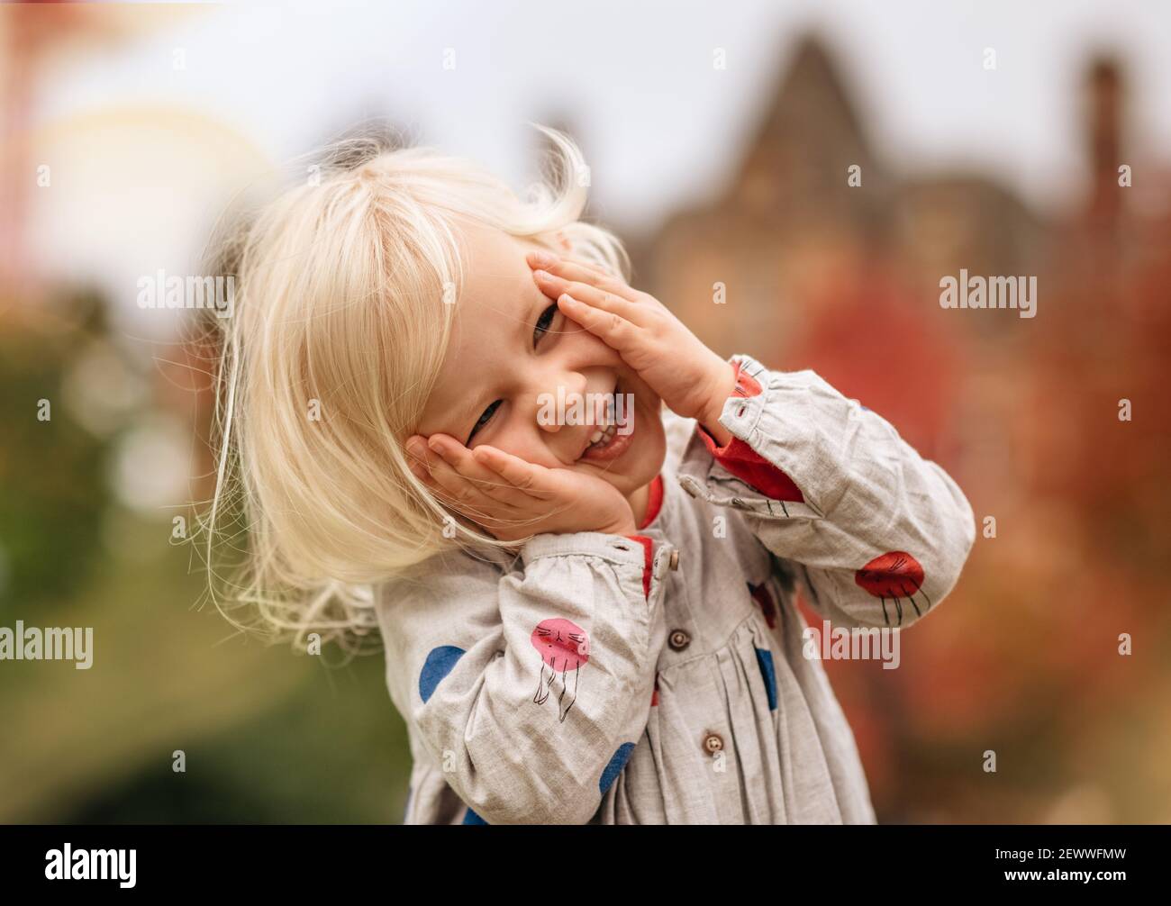 portrait of a little girl fooling around in a city Stock Photo - Alamy