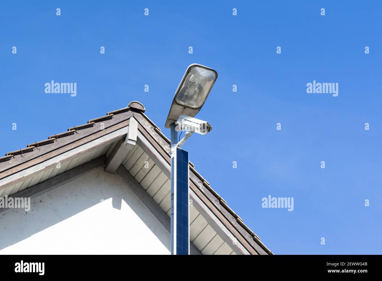 white solar powered surveillance camera in front of a house facade ...