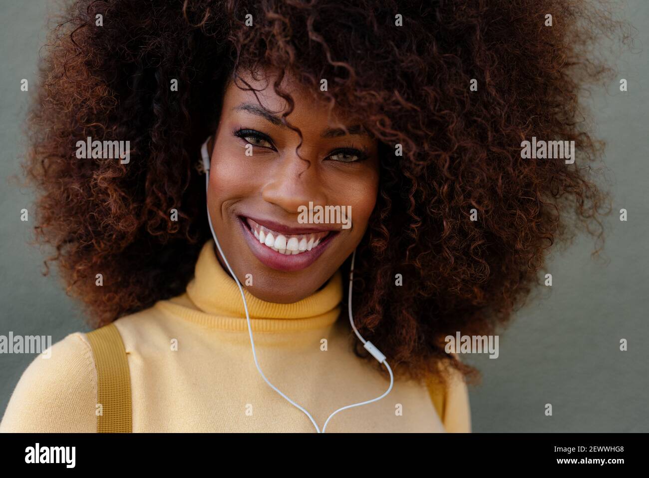 Black Woman with afro hair listening to music with a backpack on her ...