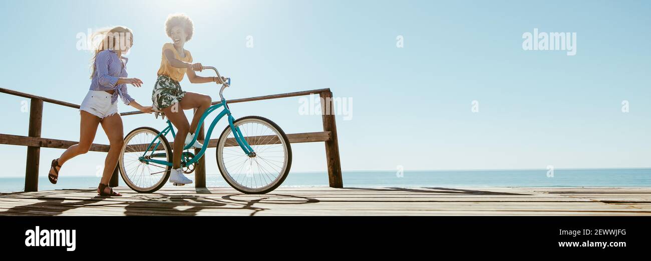Two happy women running together on boardwalk hi-res stock photography ...