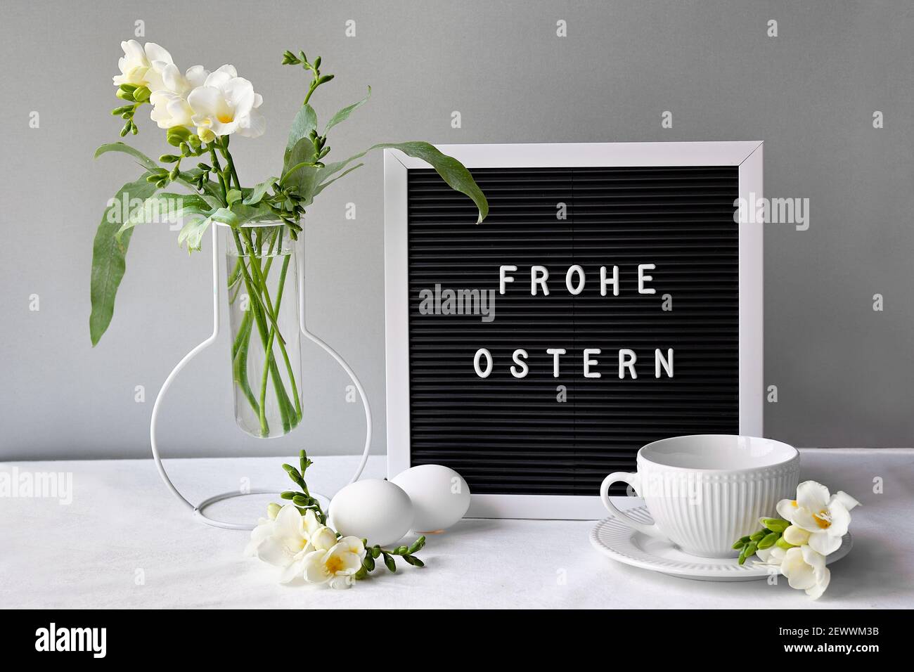 Text Happy Holidays on letter board with spring freesia flowers and tea ...