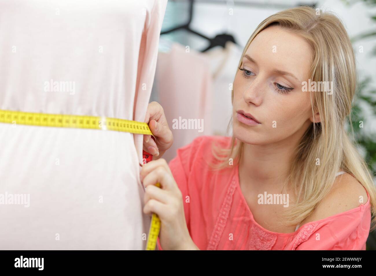 seamstress measuring waist of mannequin Stock Photo - Alamy