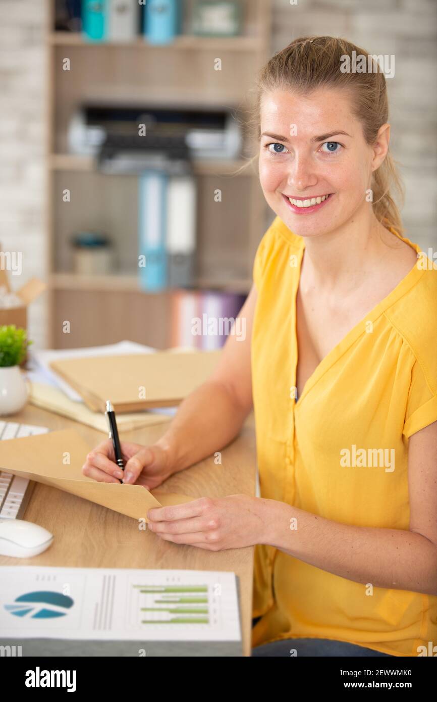 female office worker writing on an envelope Stock Photo - Alamy