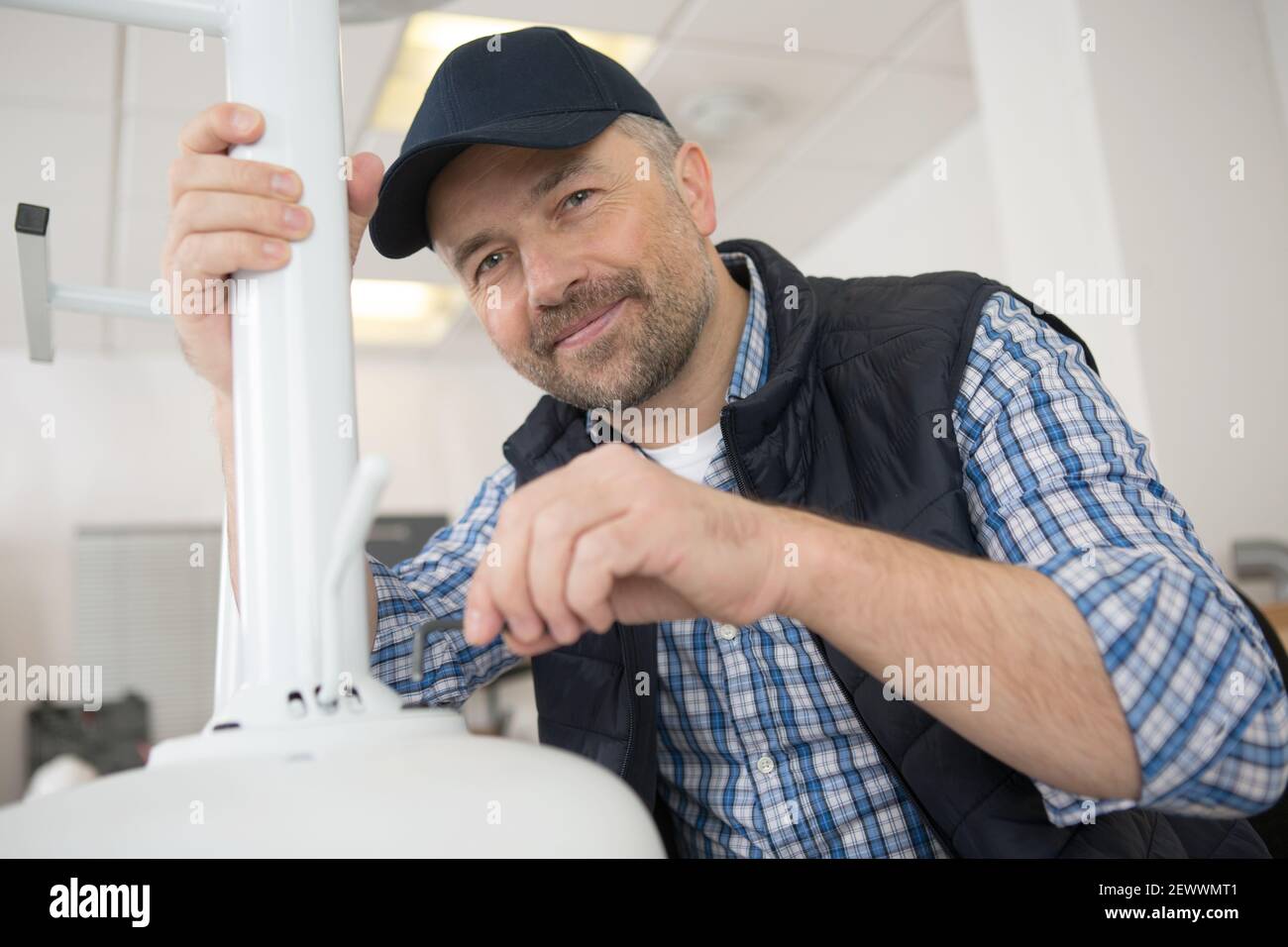 man assembling a metal chair with an allen-key Stock Photo - Alamy