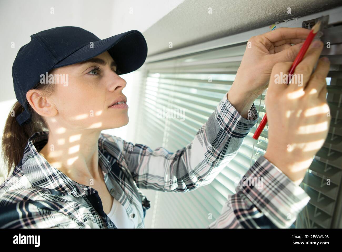 female builder installing window blinds in a building Stock Photo - Alamy