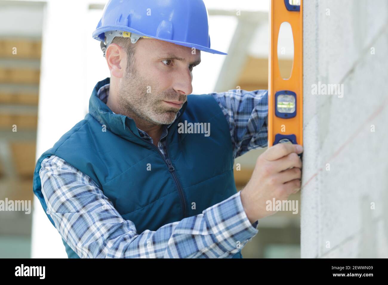 worker control wall near window using level tool Stock Photo - Alamy