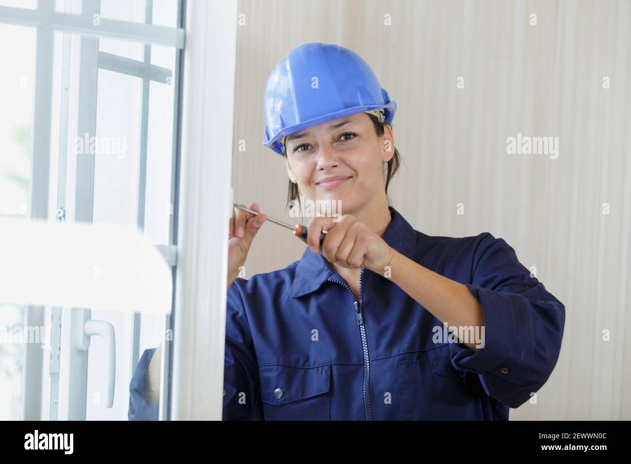 young woman unscrews the fixing screws of the window handle Stock Photo ...