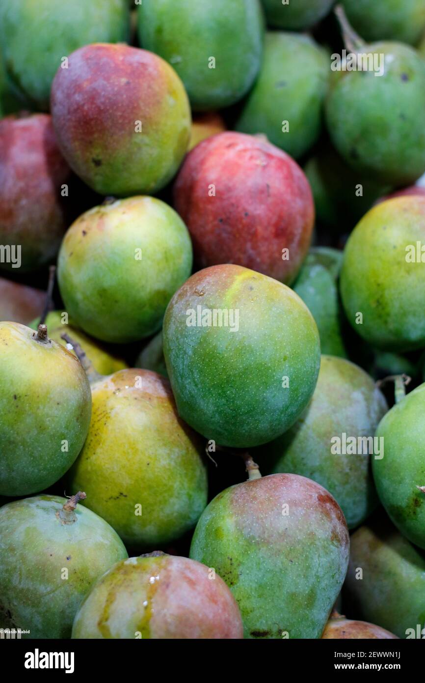 A vertical closeup shot of a pile of ripe mangos at a market Stock ...