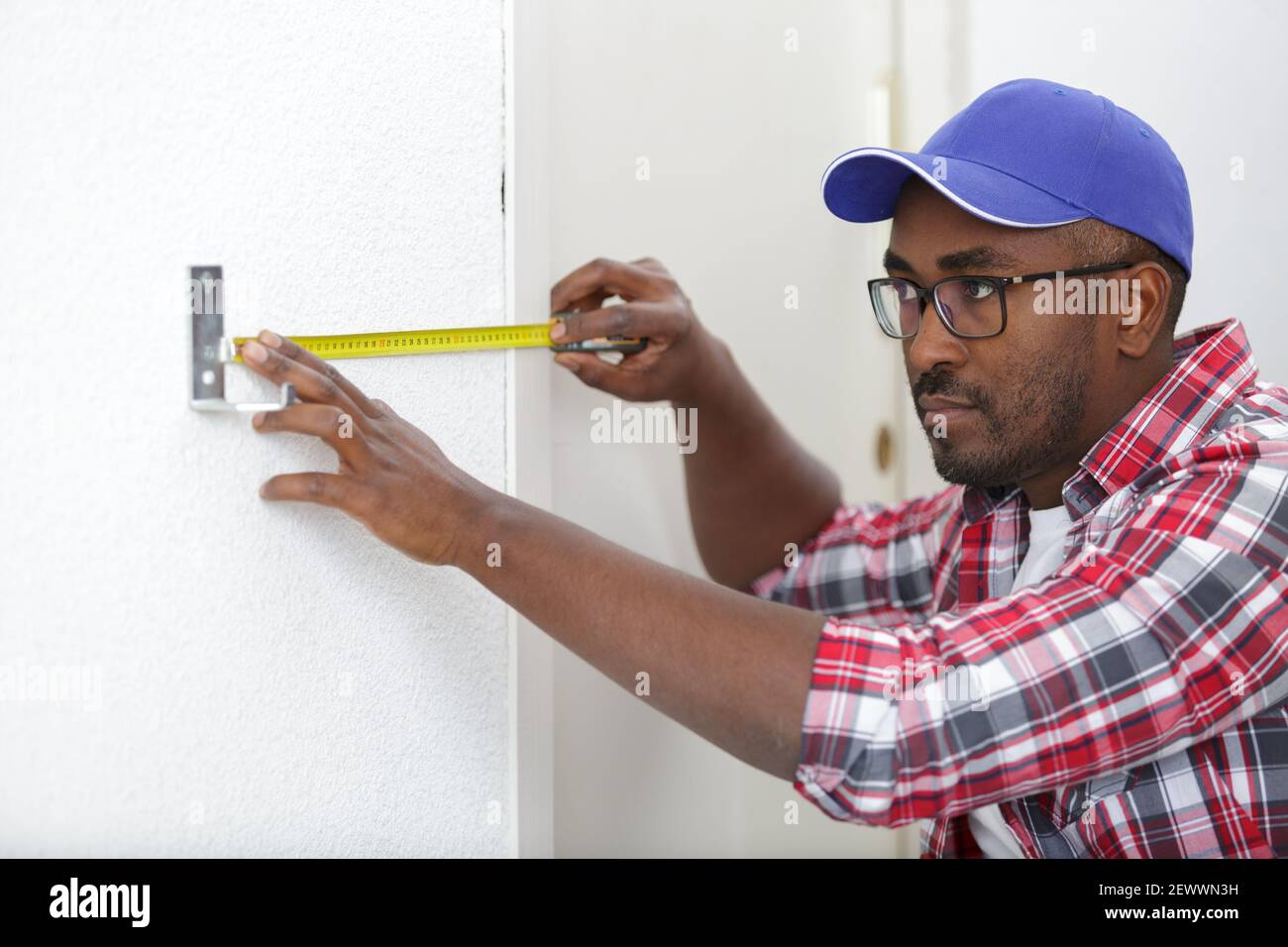 male worker measuring a wall Stock Photo - Alamy