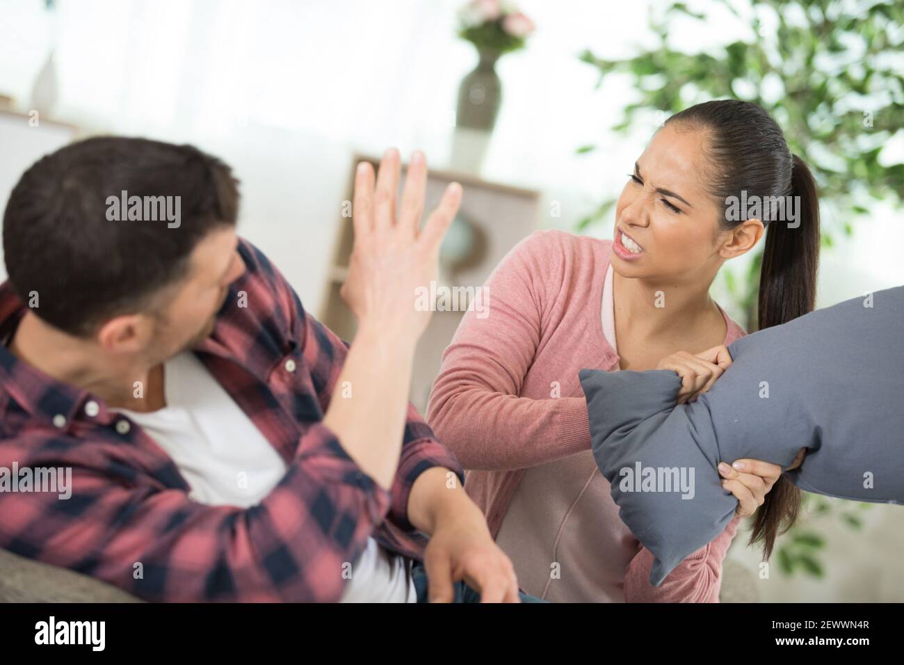 man and angry woman having pillow fight Stock Photo - Alamy
