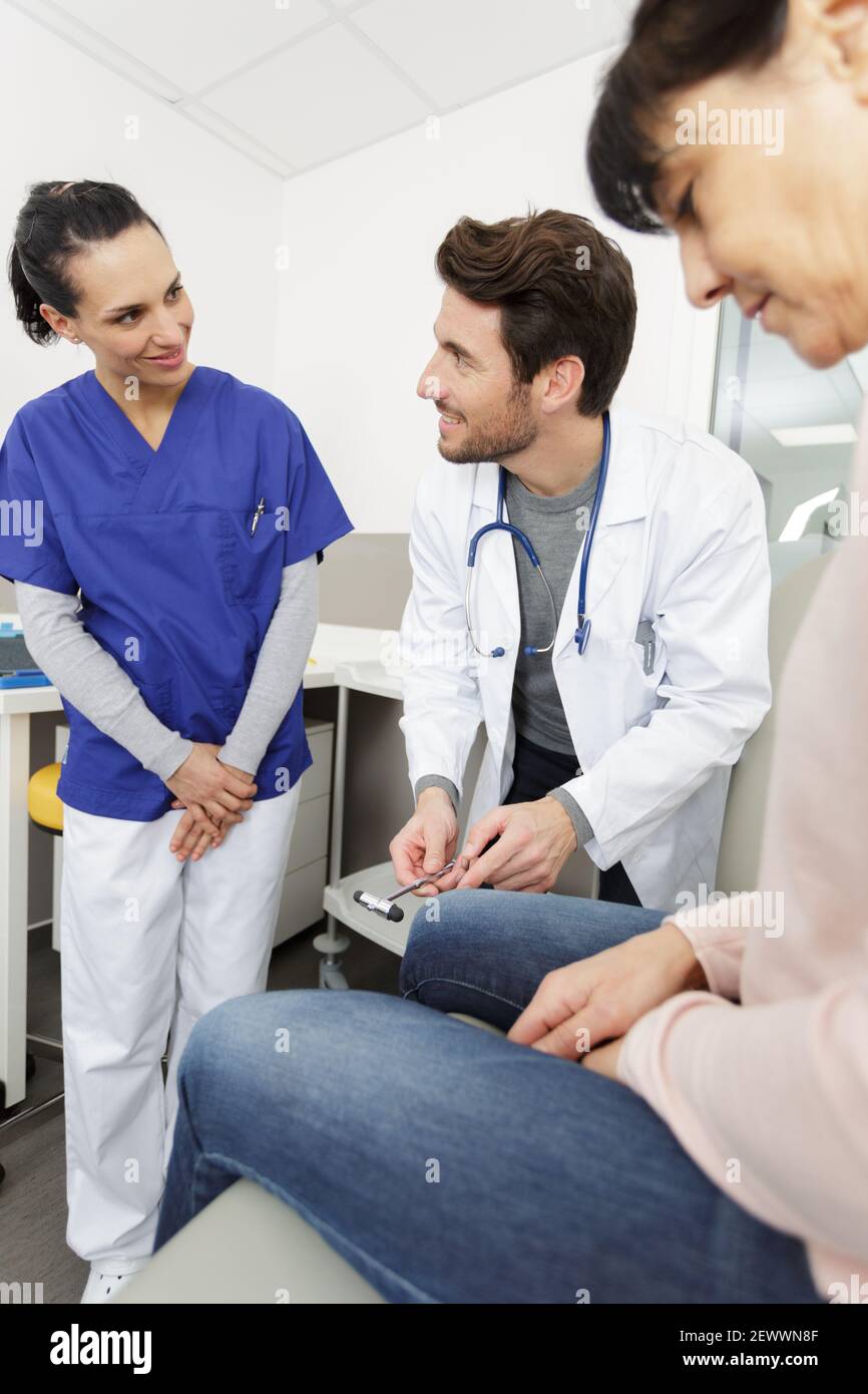 doctor testing knee reflex during medical checkup Stock Photo - Alamy