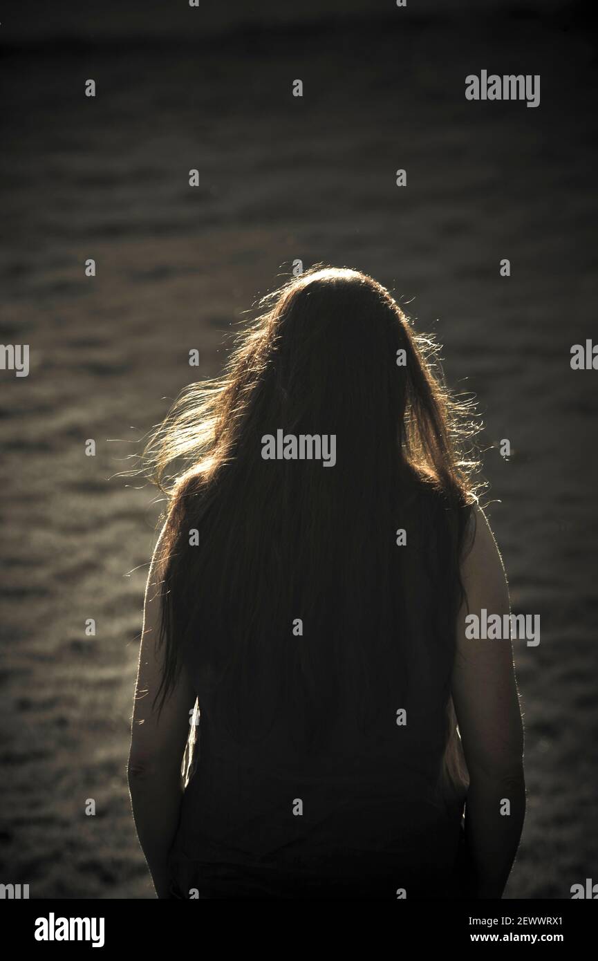 back of head and shoulders of a woman with dark long hair Stock Photo ...