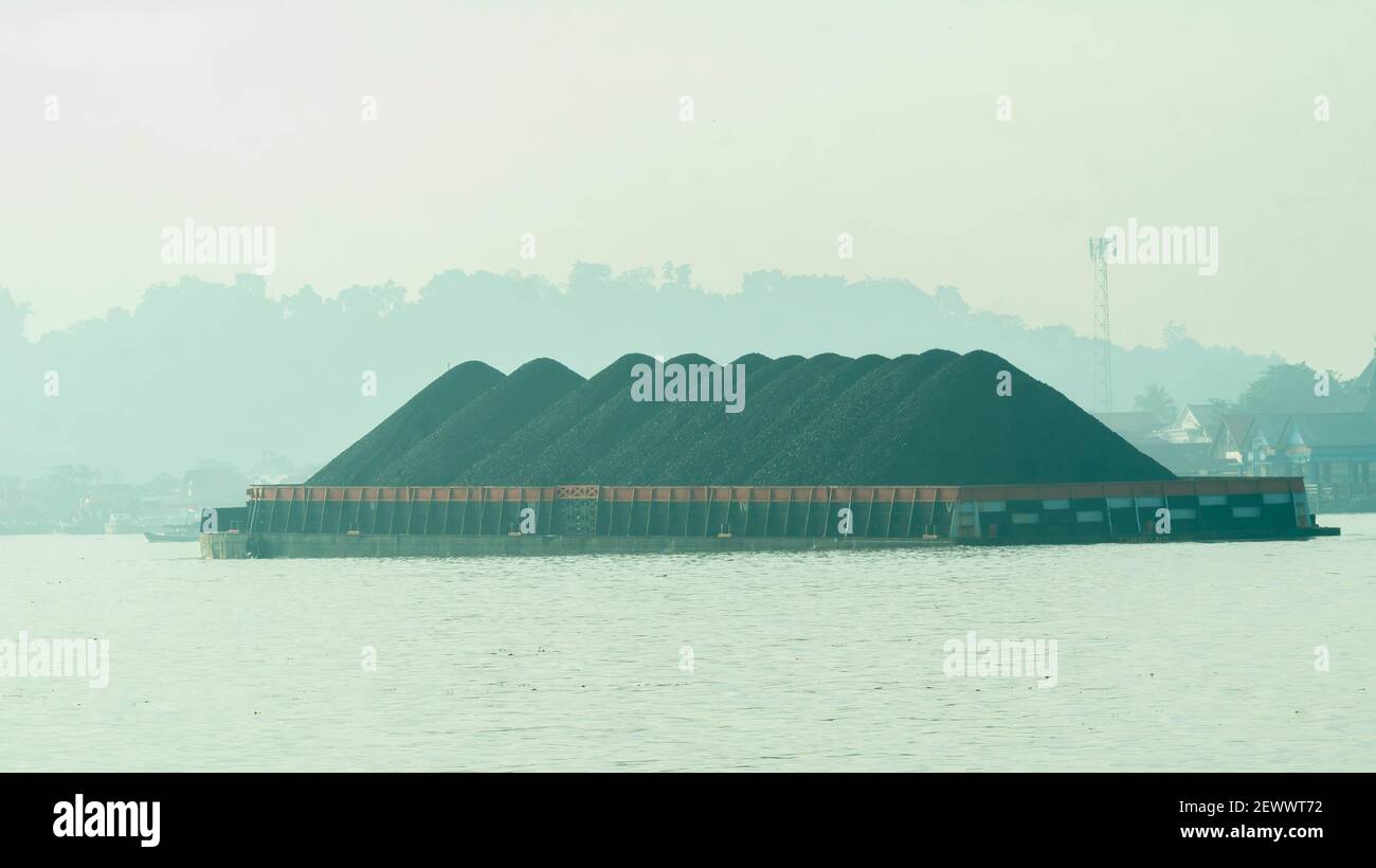 Tugboat dragging barge full of coal, Mahakam River. Taken from behind ...