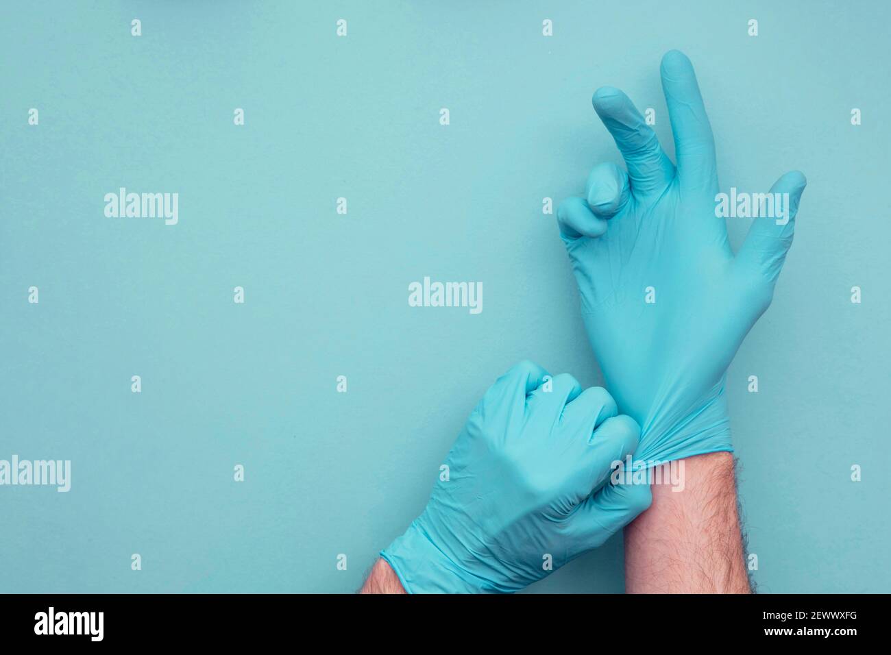 Doctors hand putting on a pair of blue protective surgical gloves Stock ...