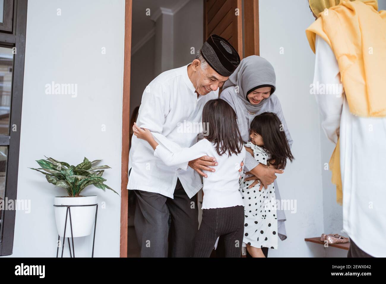 Happy asian muslim aged couple meeting kids and grand children at ...