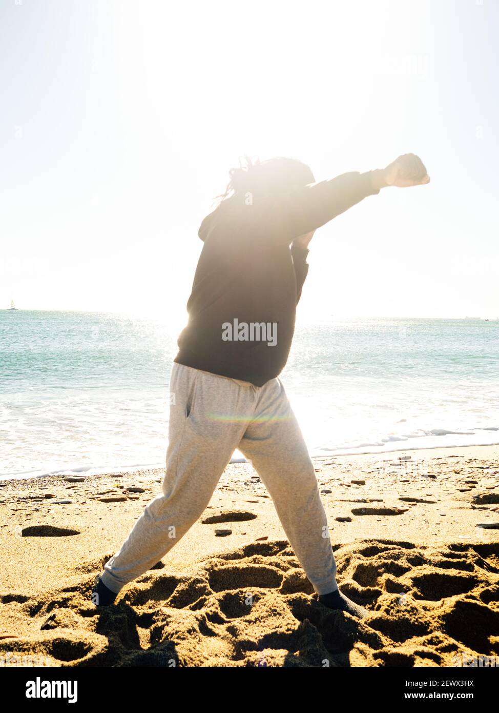 A vertical shot of a young African-American male practicing boxing on a ...