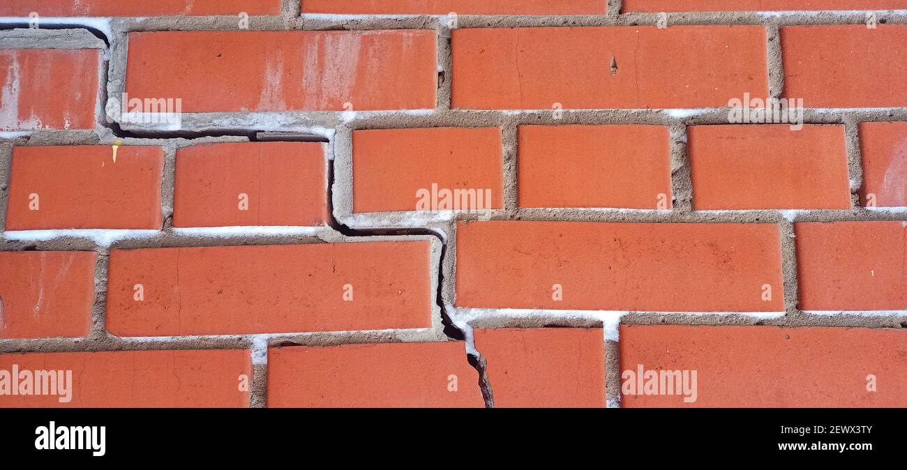 The red brick wall cracked. Crack on the red wall. The brick wall fell ...