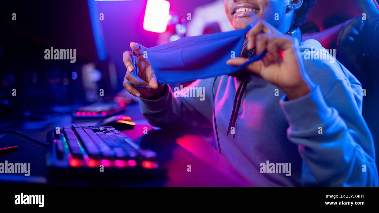 Streamer African American gamer woman holds safety mask protect ...