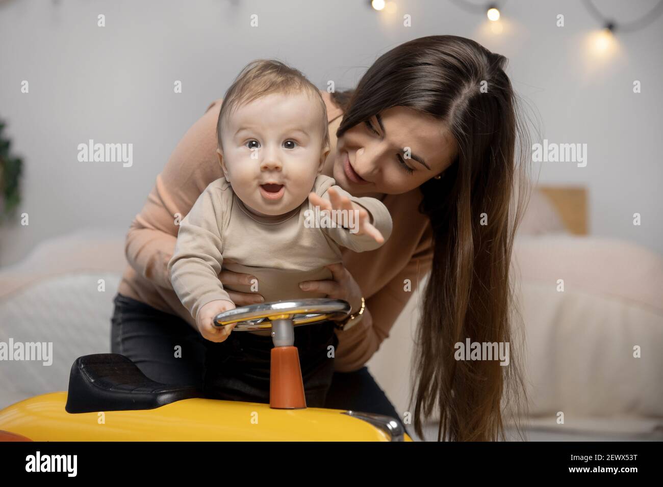 Concept Young baby driver. Mother plays with her little son and big toy ...