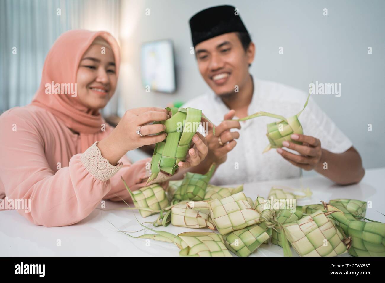 beautiful muslim couple asian making ketupat rice cake at home using ...