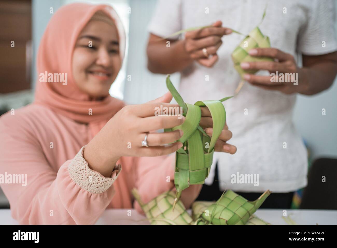 beautiful muslim couple asian making ketupat rice cake at home using ...