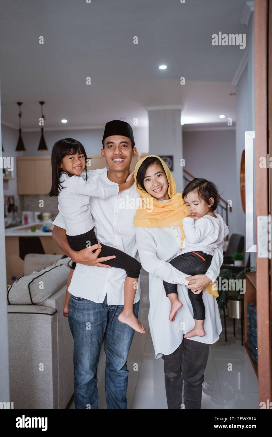 portrait of muslim family standing in front of their front door house ...