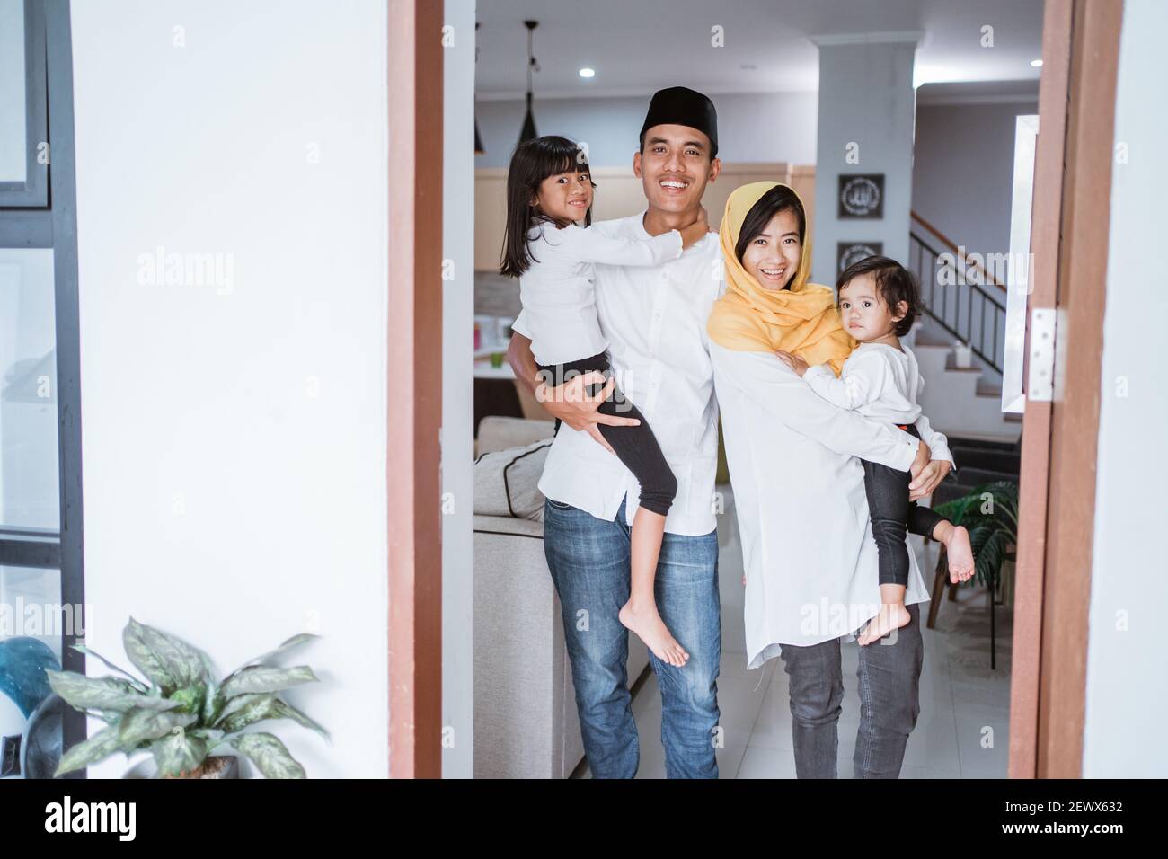 portrait of muslim family standing in front of their front door house ...