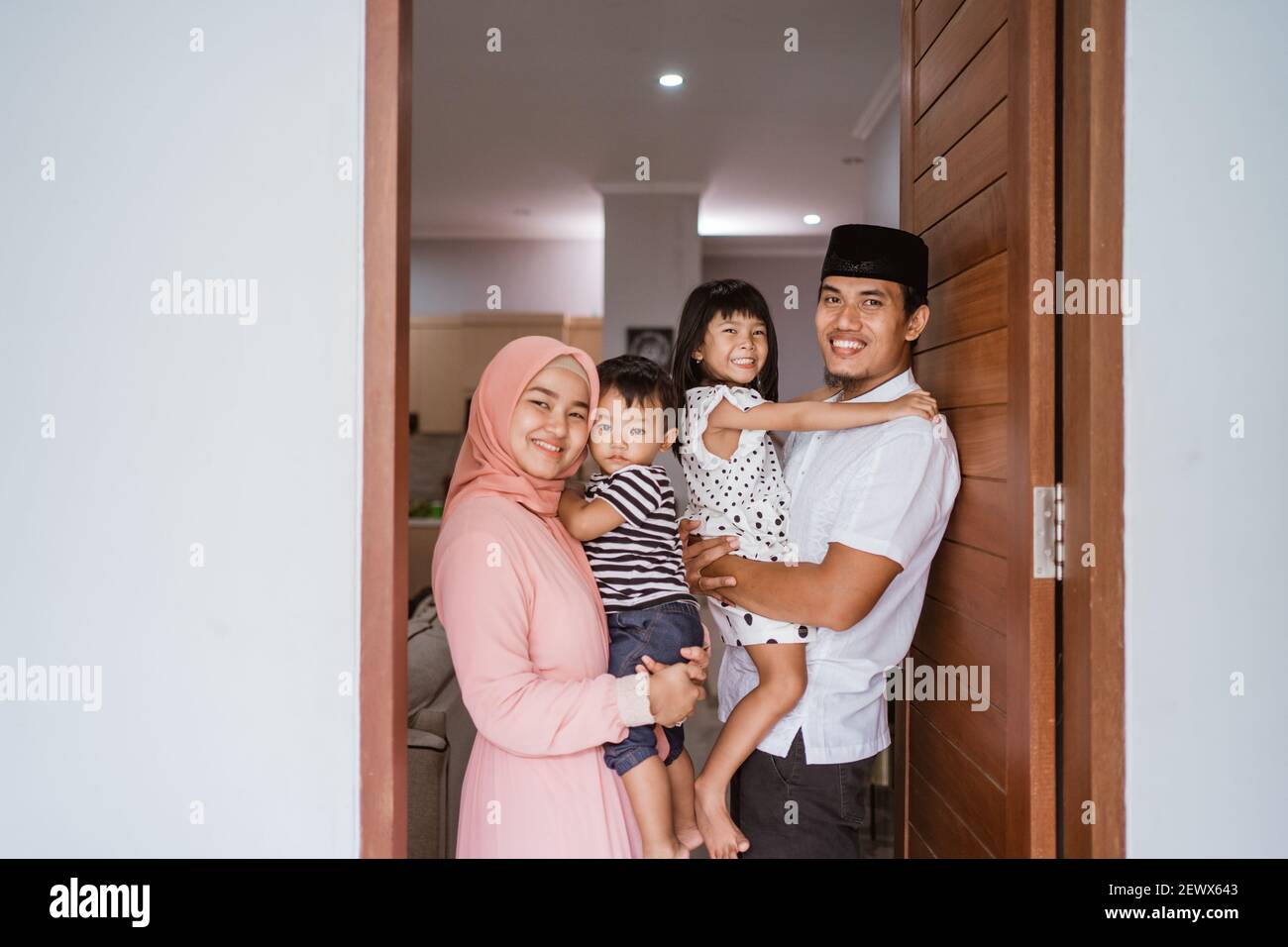 portrait of muslim family standing in front of their front door house ...