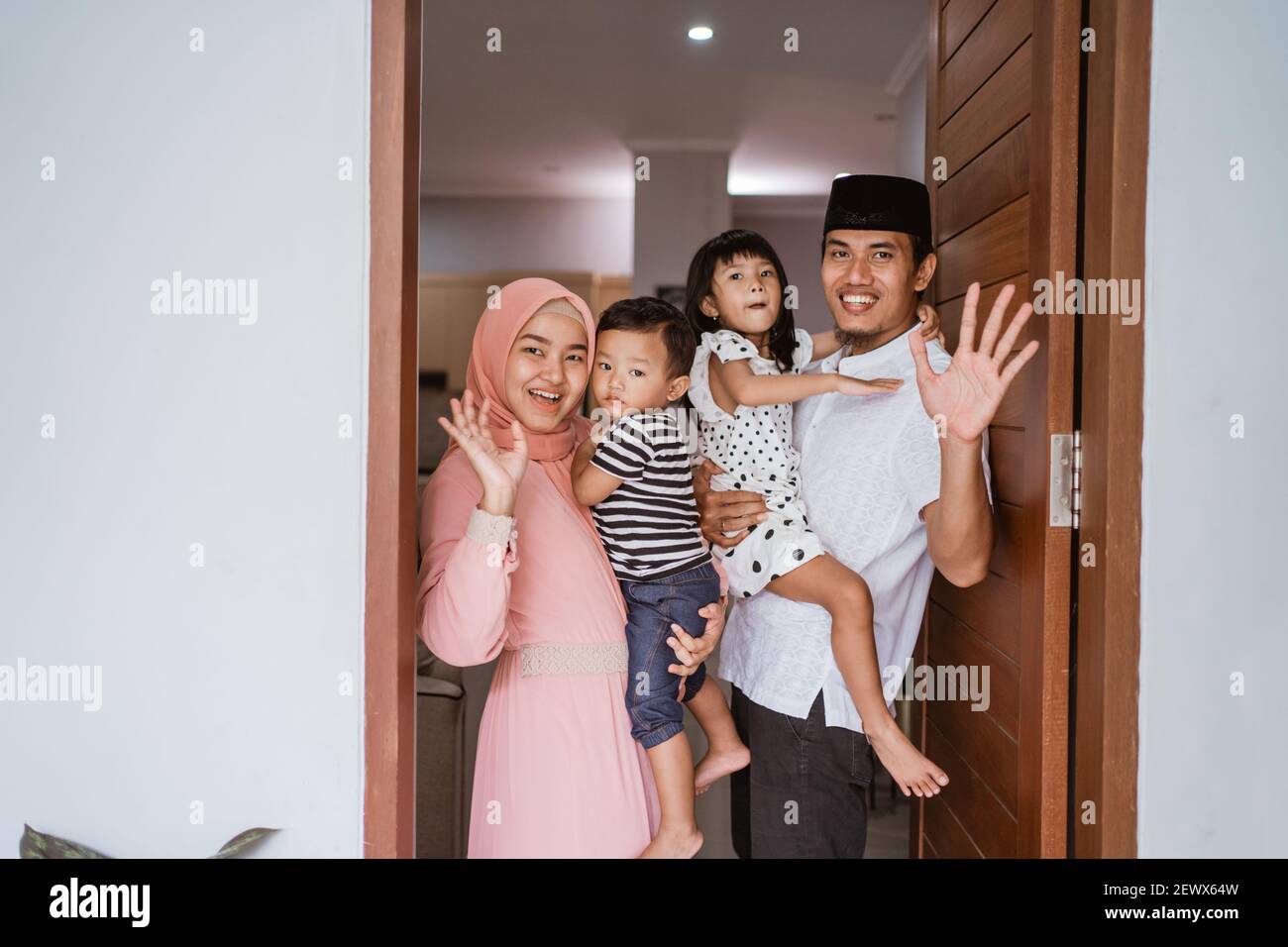 portrait of muslim family standing in front of their front door house ...