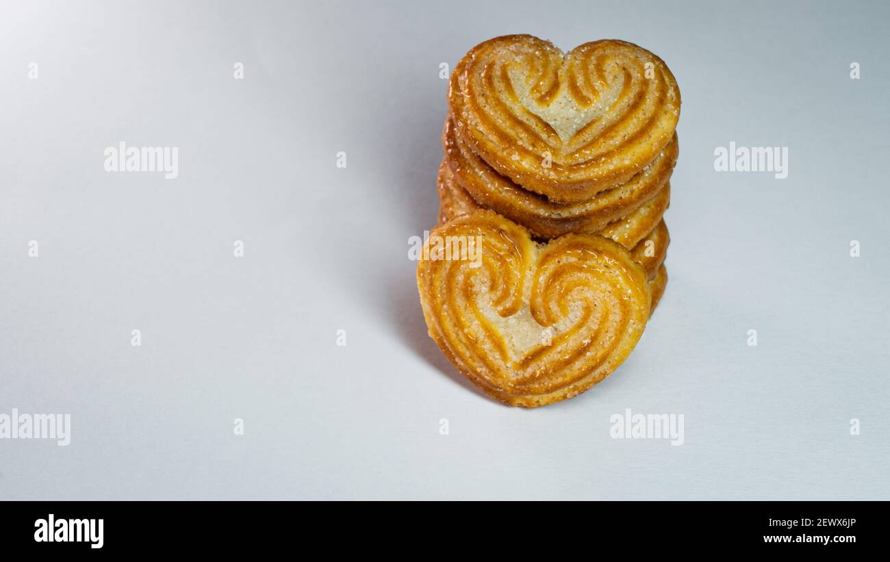 Close up of a little heart shaped biscuit placed in front of a vertical ...