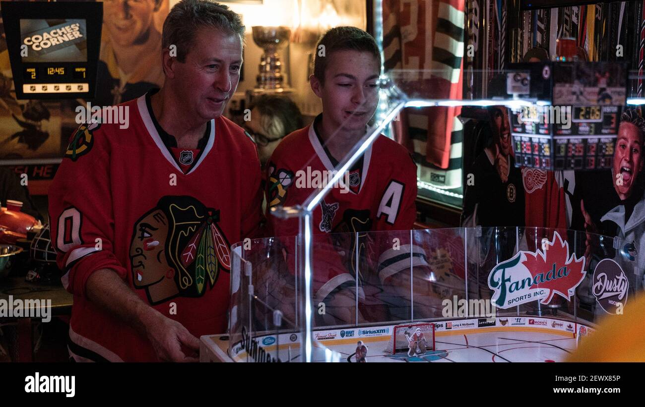 Kenn Shaw (left) with his son, Landen, in his hockey-themed fan cave in ...