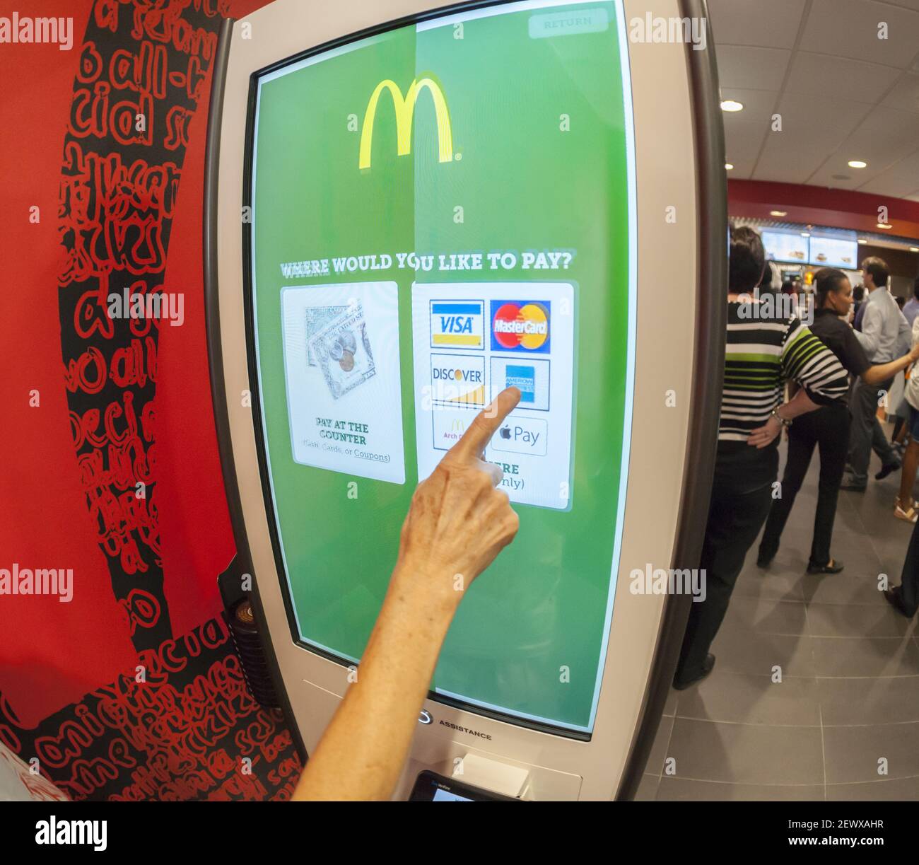 A diner chooses her payment method at a "Create Your Taste" kiosk at a ...