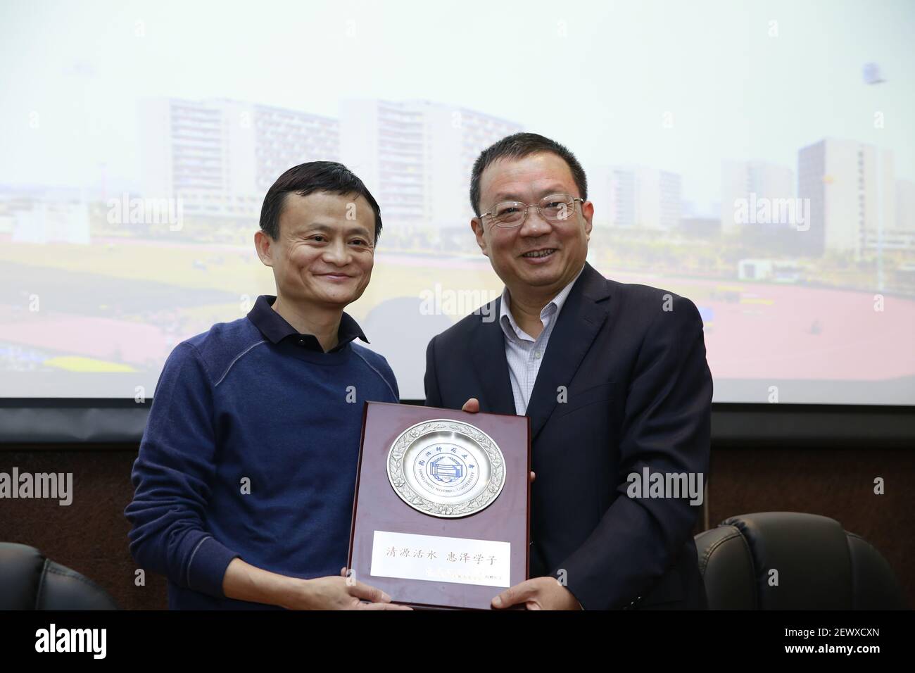 --FILE--Jack Ma, left, takes photos with the headmaster of Hangzhou ...